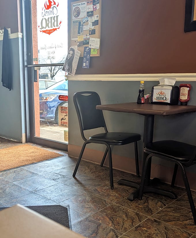 A corner table waits for its next hungry visitor, napkin dispenser standing ready for the delicious mess that's about to happen.