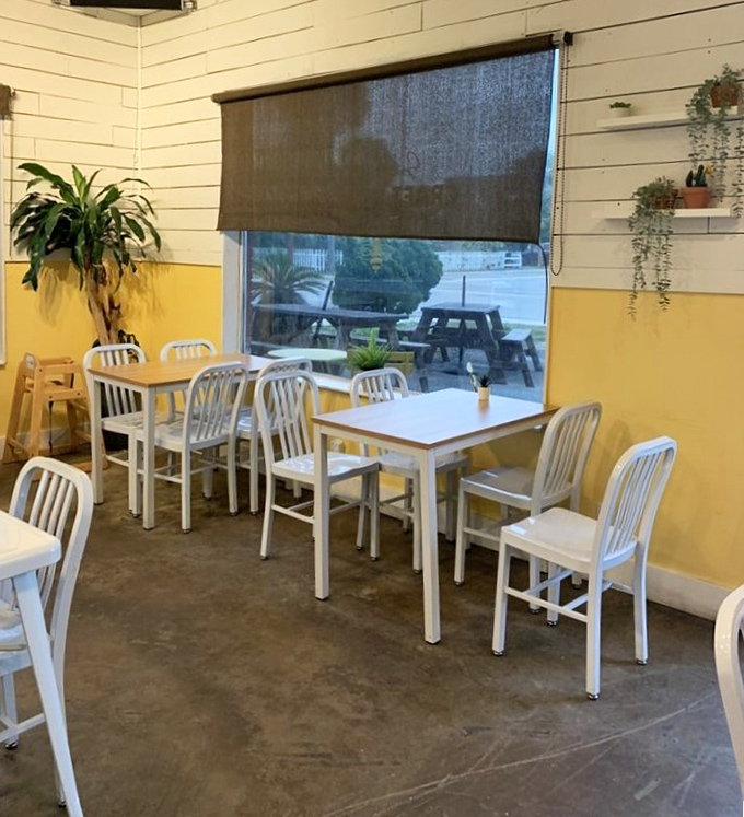 The sunny dining area, with its simple white tables against yellow walls, creates the perfect backdrop for morning conversations.