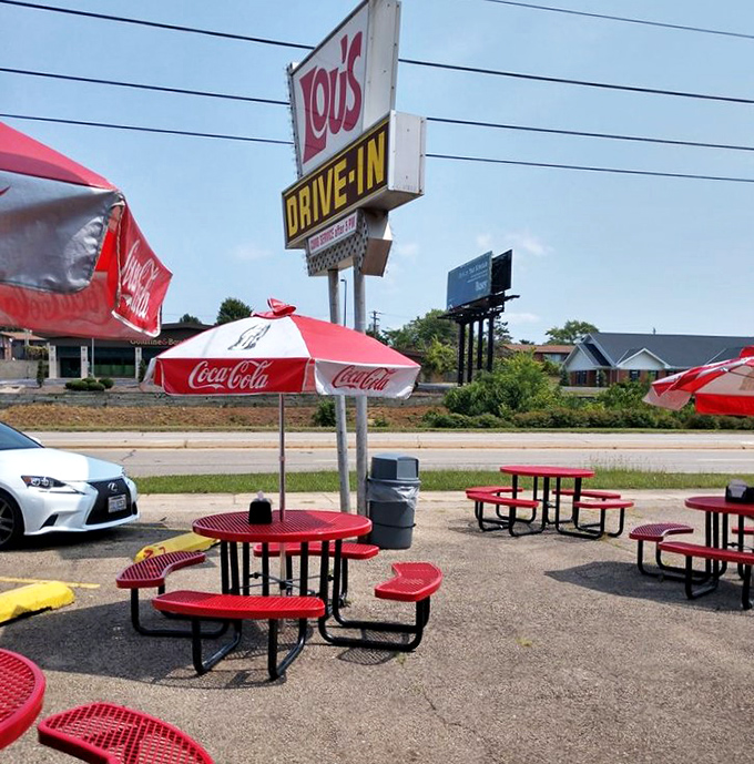 Red picnic tables invite strangers to become temporary neighbors, sharing nothing but space and an appreciation for honest American food.