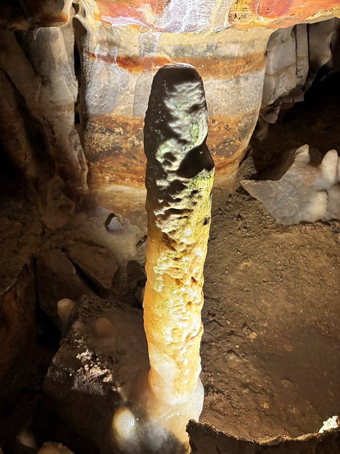 This towering stalagmite reaches upward like a stone monument, growing imperceptibly but persistently toward its stalactite partner above.