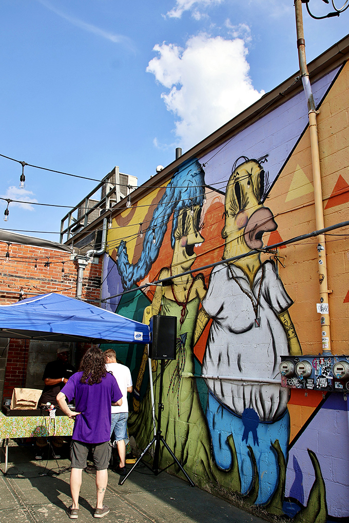 The vibrant outdoor mural serves as a colorful backdrop for patio gatherings when gamers need fresh air between high-score attempts.