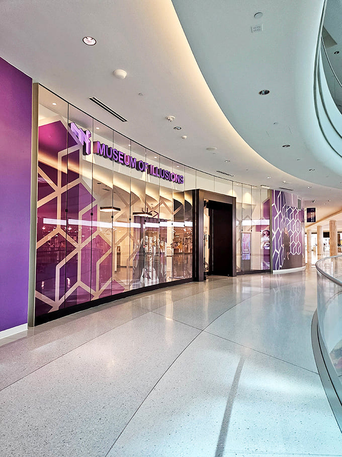 The sleek, modern exterior of the Museum of Illusions stands out with its signature purple branding. Reality distortion field, activate!