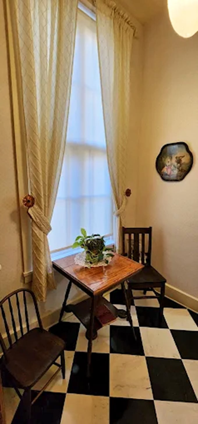A quiet corner vignette where Victorian sensibilities meet functional design. That small table has probably held everything from love letters to telegram deliveries.