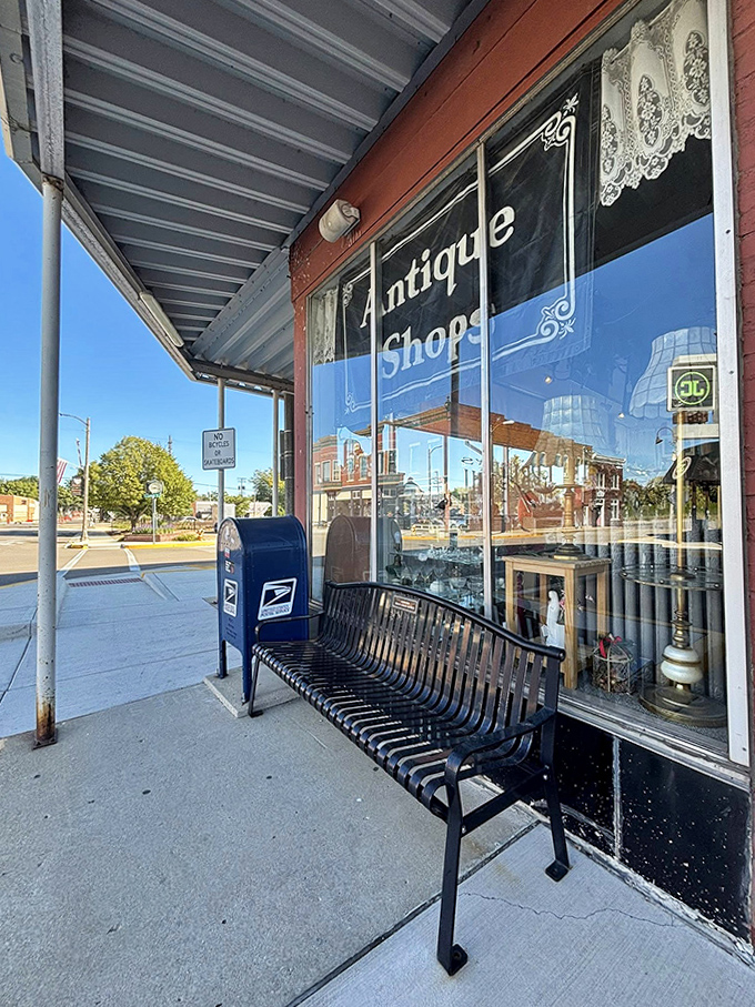 This sidewalk bench invites weary shoppers to rest while contemplating their next antiquing conquest &ndash; the blue mailbox standing sentinel nearby.