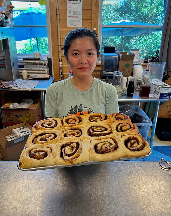 Behind every great pastry is a dedicated baker &ndash; fresh cinnamon rolls being proudly displayed before they disappear into happy customers' hands.