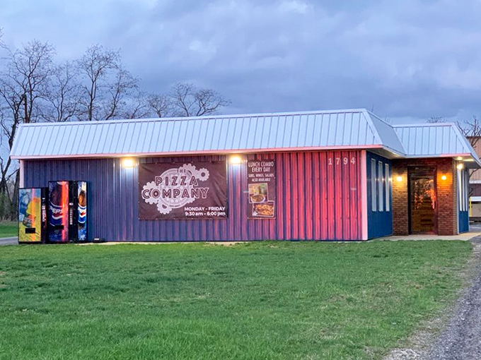 The Pizza Company lights up as evening falls, its colorful building serving as a beacon for those seeking pizza satisfaction after dark.