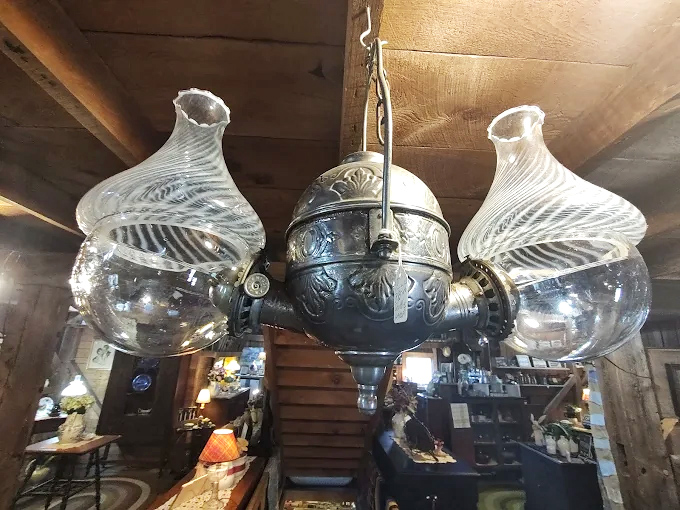This exquisite antique lamp with its ornate metalwork and delicate glass globes once illuminated conversations in a Victorian parlor.