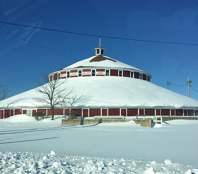 Winter blankets the barn in snow, its red walls providing a striking contrast to the white landscape of rural Wisconsin.