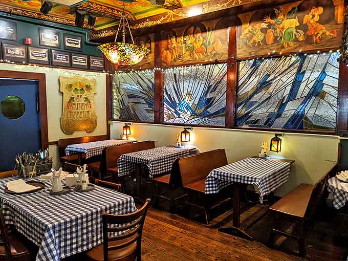 Cozy booths framed by stunning stained glass panels create intimate dining nooks where conversations flow as freely as the German beer.