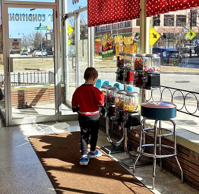 Vintage candy machines stand sentinel by the door, offering colorful temptations that bridge generations of sweet-toothed visitors.