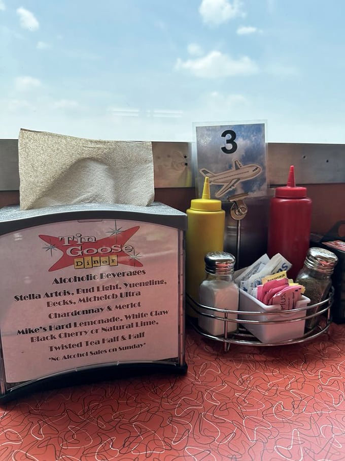 Every table tells a story with its perfectly arranged condiment caddy – the airplane marker reminding you this isn't just any diner experience.