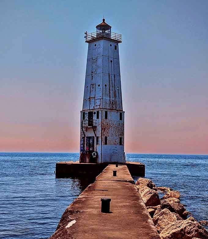 Dusk: The lighthouse's silhouette creates a perfect frame for Lake Michigan's pastel sunset &ndash; nature's version of a masterpiece painting.