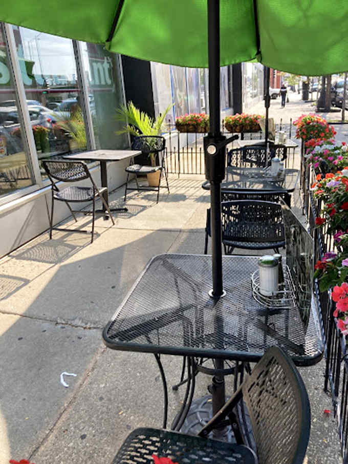 The outdoor patio offers urban breakfast al fresco, with colorful flowers softening the city's concrete edges.