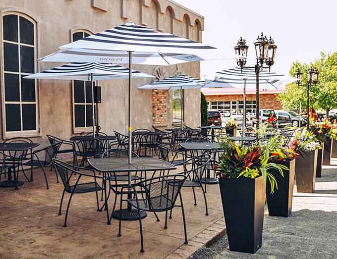 Al fresco dining under striped umbrellas surrounded by colorful planters &ndash; summer evenings were made for patios like this.
