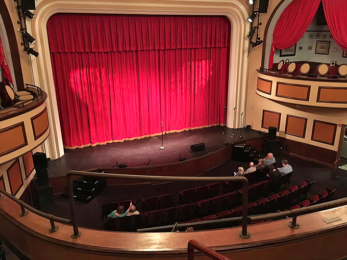 The rich red curtain—theater's universal symbol of anticipation—moments before it parts to reveal another world of imagination and storytelling.