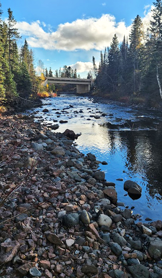 Rocks: The Brule River flows gently here, a deceptively peaceful prelude to its dramatic plunge and mysterious disappearance downstream.