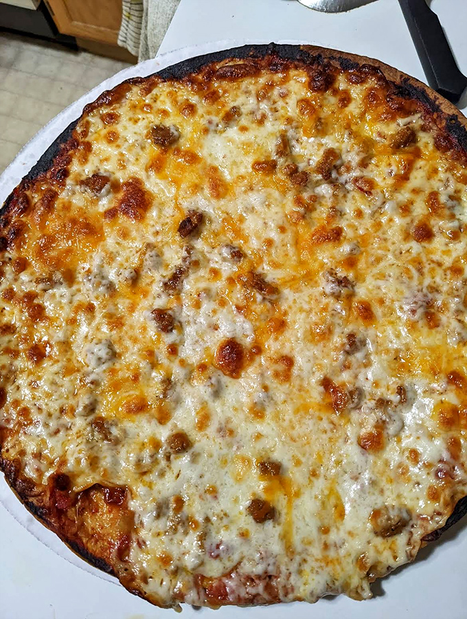 A freshly baked pizza with perfectly melted cheese demonstrates why Marino's has mastered multiple Italian-American classics.
