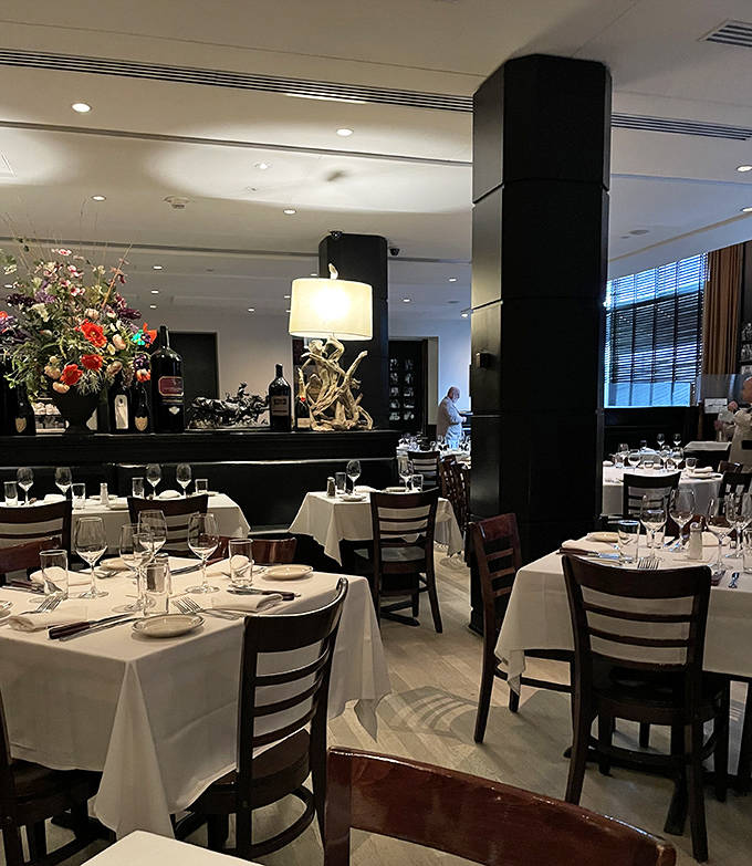 Another angle of dining room perfection &ndash; where white tablecloths meet warm lighting in the cathedral of carnivorous delights.