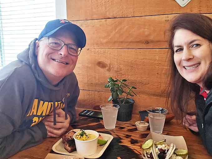Happy diners share a moment of barbecue bliss, their plates showcasing the bounty that keeps customers coming back.