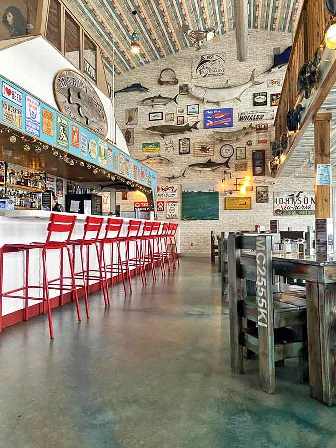 High ceilings and mounted fish create an airy, maritime atmosphere where red bar stools invite patrons to belly up for fresh catches and local brews.
