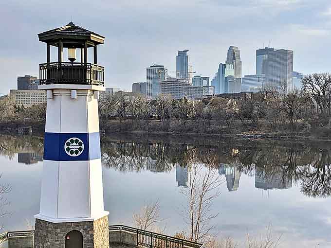 The lighthouse stands as a proud sentinel against Minneapolis' impressive skyline, creating a perfect blend of nature and urban beauty.