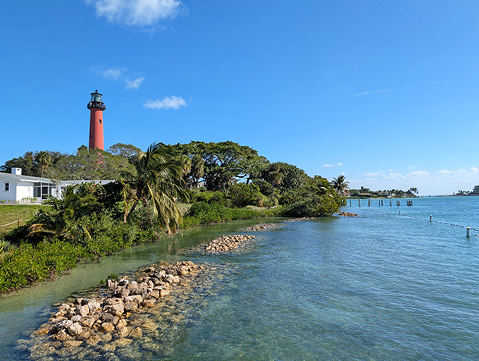 Where land meets sea, the lighthouse creates the perfect Florida postcard&mdash;palm trees, blue water, and that iconic red tower.
