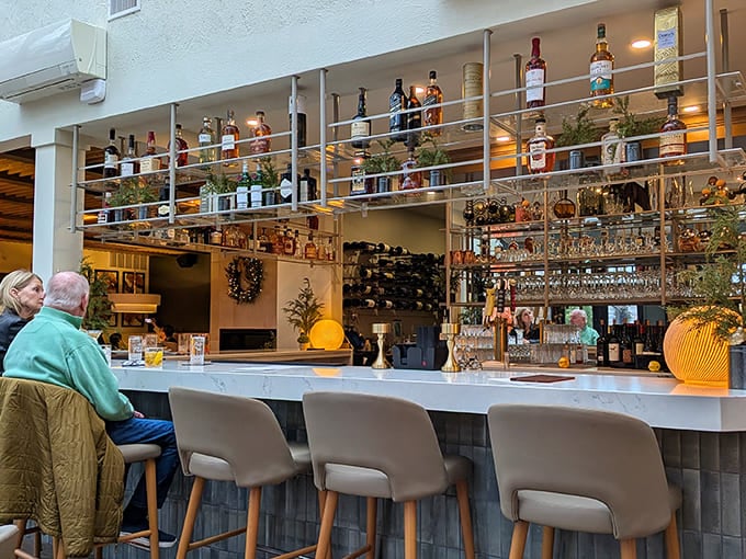 The bar area gleams with bottles and possibilities, inviting guests to settle in for cocktails and conversation in this thoughtfully designed space.