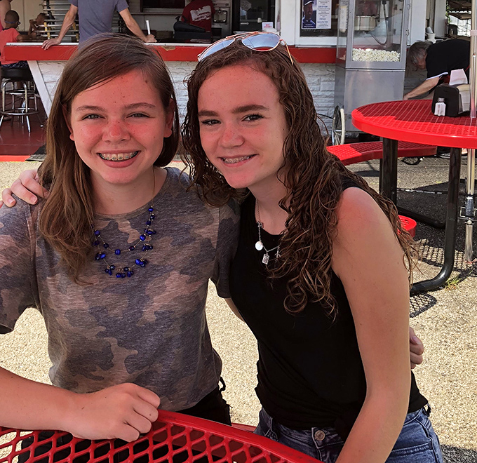 The outdoor dining area at Lou's becomes a community gathering spot where memories are made between bites of perfect burgers.