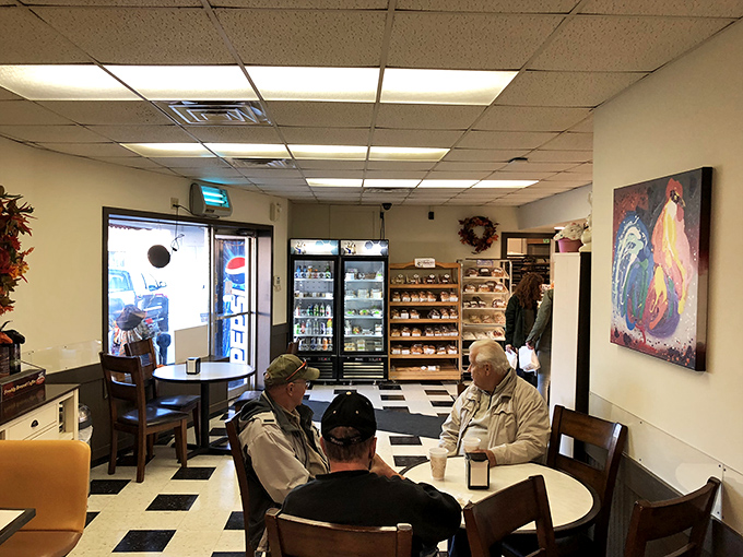A peek inside the bakery's heart, where glass cases display the day's fresh creations and loyal customers casually enjoying a hearty cup of coffee.