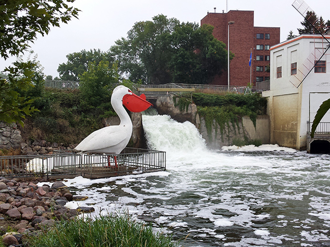 The giant pelican statue guards the rushing waters with its oversized bill, like a quirky superhero protecting the town's liquid treasure.