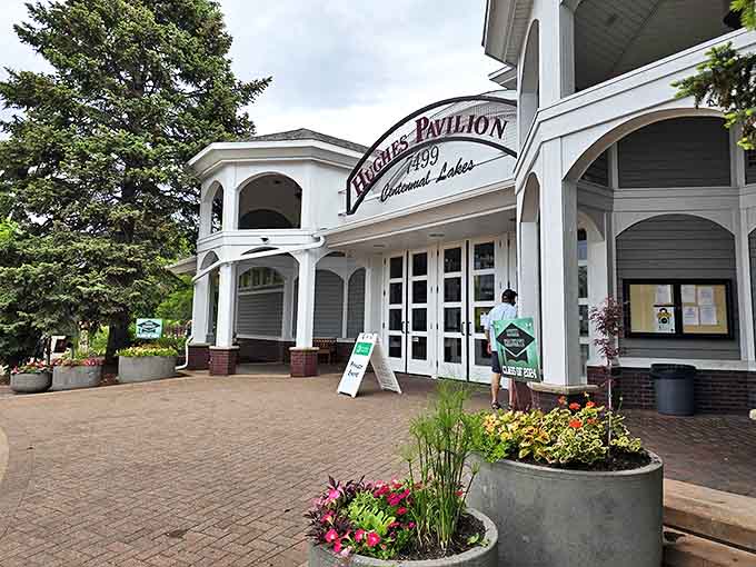 Hughes Pavilion welcomes visitors with its charming architecture, serving as both a practical hub for park activities and a picturesque landmark against the greenery.