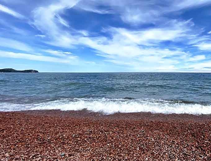 Morning light turns Lake Superior into liquid silver, creating a magical backdrop for the pink stone shoreline.