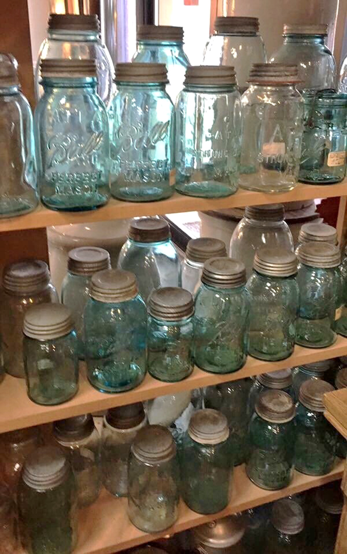 Vintage canning jars stacked like crystalline towers &ndash; their aqua glass catching the light while preserving memories of grandma's kitchen.