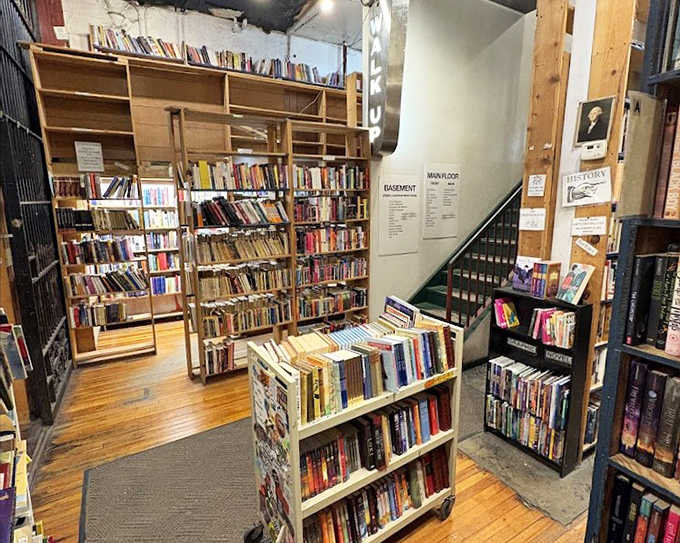 The main floor's wooden shelves create a warm, inviting atmosphere where browsers can lose themselves for hours among countless titles.