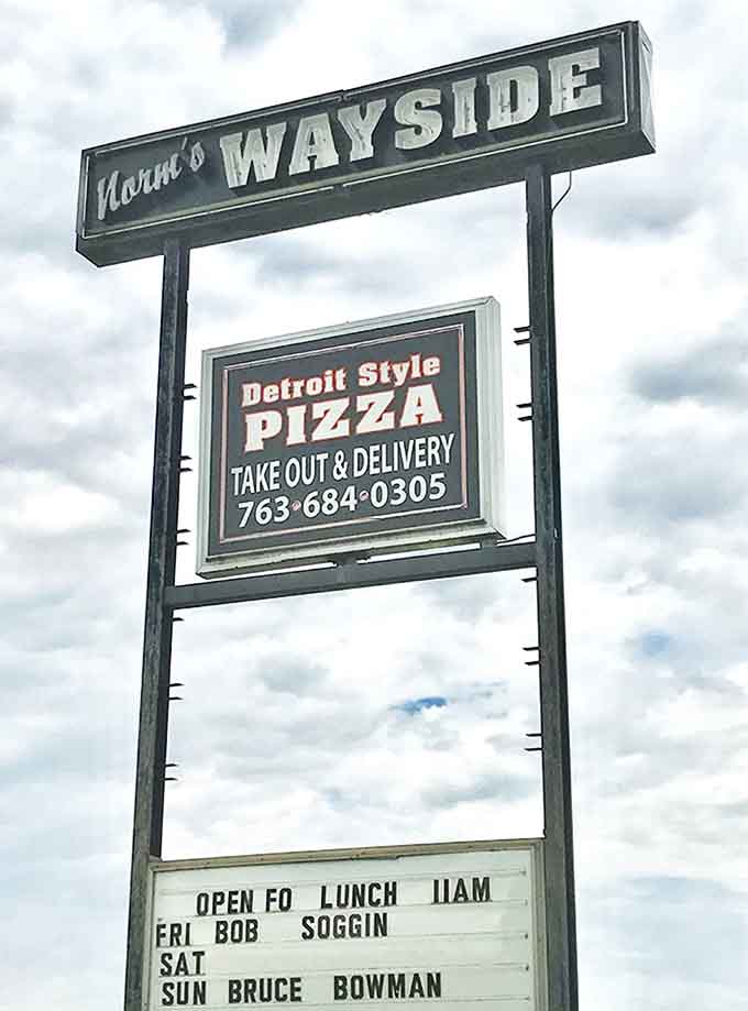 The roadside sign serves as a beacon for hungry travelers, promising Detroit-style pizza and live music &ndash; two essential food groups.