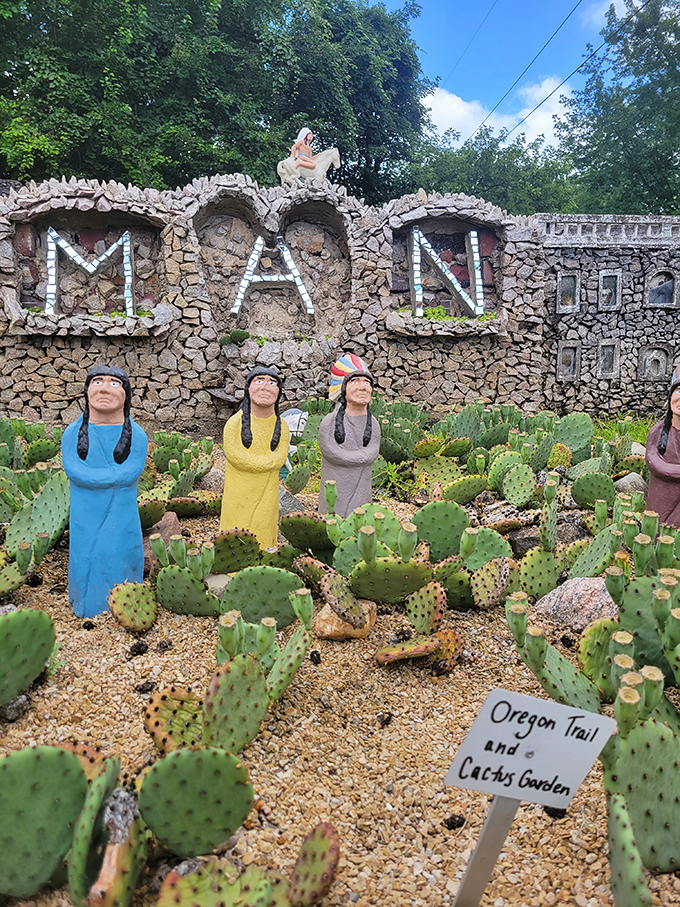 Prickly pear cacti surround colorful figurines in this desert-themed vignette, creating an unexpected southwestern scene in the Ohio landscape.