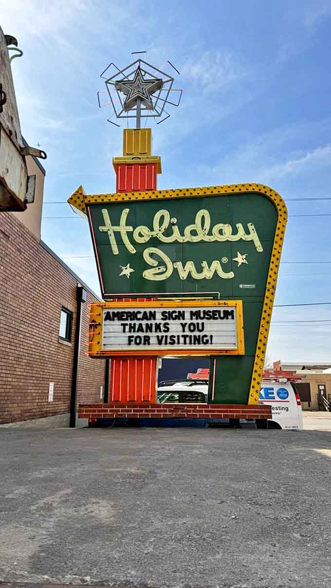 The Holiday Inn sign stands sentinel in the parking lot, its star-topped spire a landmark for generations of American travelers seeking rest.