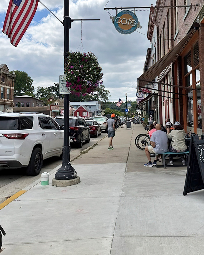 Hanging flower baskets and welcoming storefronts create an atmosphere that makes you want to park and explore instead of just driving through.