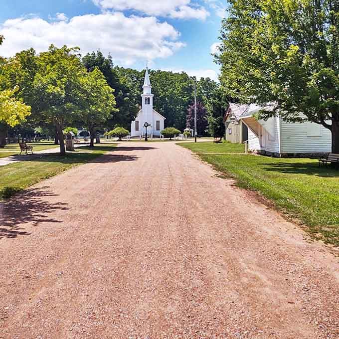 A simple dirt path leads to the white church steeple, proving that sometimes the most meaningful journeys don't require GPS.