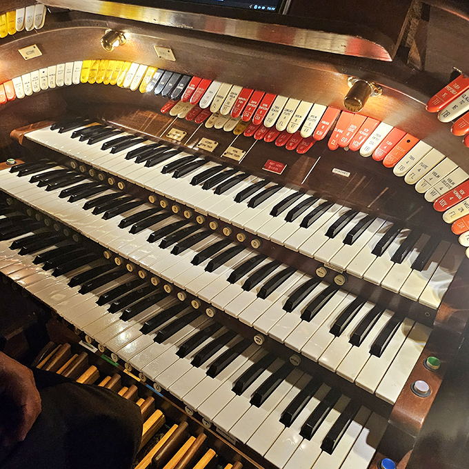 The Mighty Wurlitzer organ's keys await skilled hands to bring them to life, each note a connection to the theater's silent film beginnings.