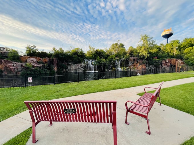 Red benches offer perfect resting spots to contemplate the falls, strategically placed for optimal viewing and peaceful reflection.