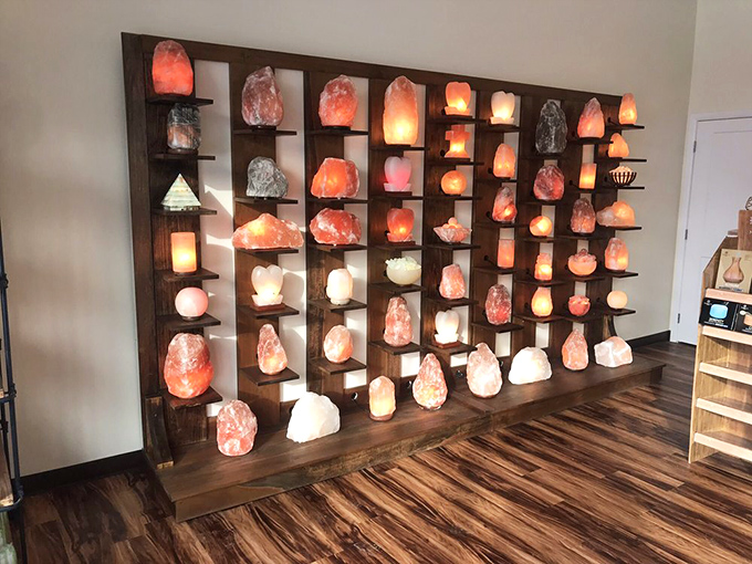 A stunning display wall showcases various salt lamps and crystals, each emitting that characteristic peaceful glow.