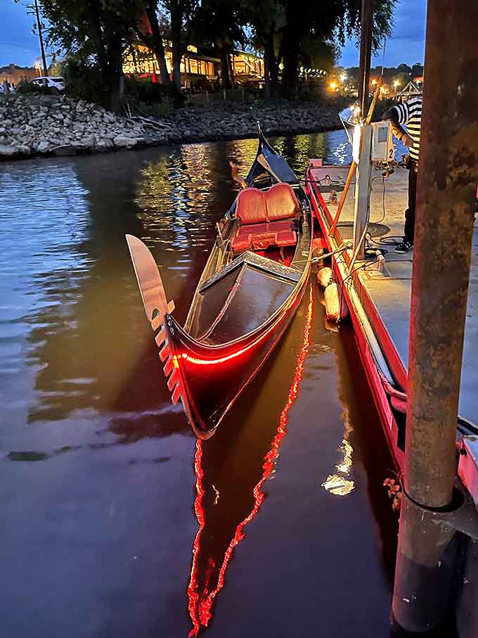 As night falls, the gondola transforms with twinkling lights, creating floating magic against the darkening water.