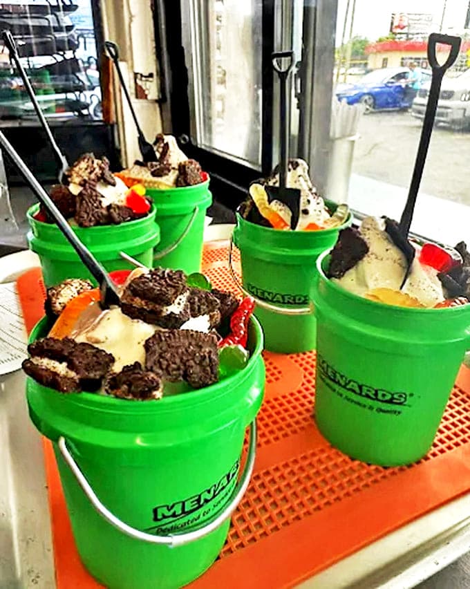 Dessert arrives in bright green buckets because regular portions are for people without imagination or proper appreciation for ice cream mountains.