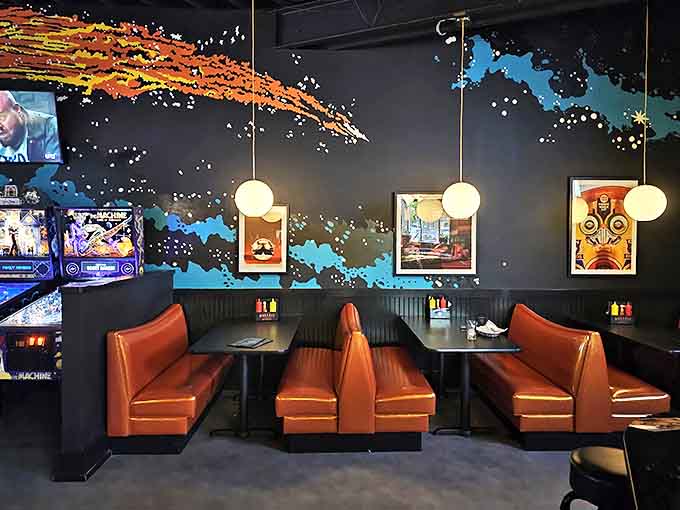 Cozy booths offer the perfect respite between games, with cosmic murals creating an otherworldly backdrop for conversations.