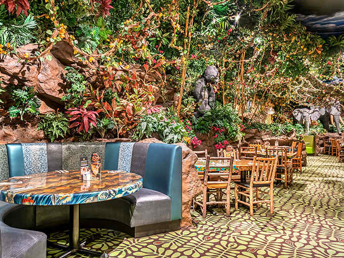 Cozy booths nestled against rock formations offer semi-private dining caves, where conversations echo slightly like whispers in a tropical grotto.