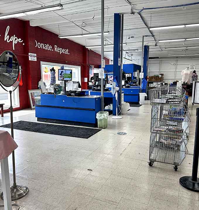 "Shop. Hope. Donate. Repeat." The red wall reminds shoppers that their treasure hunting directly supports neighbors in need.
