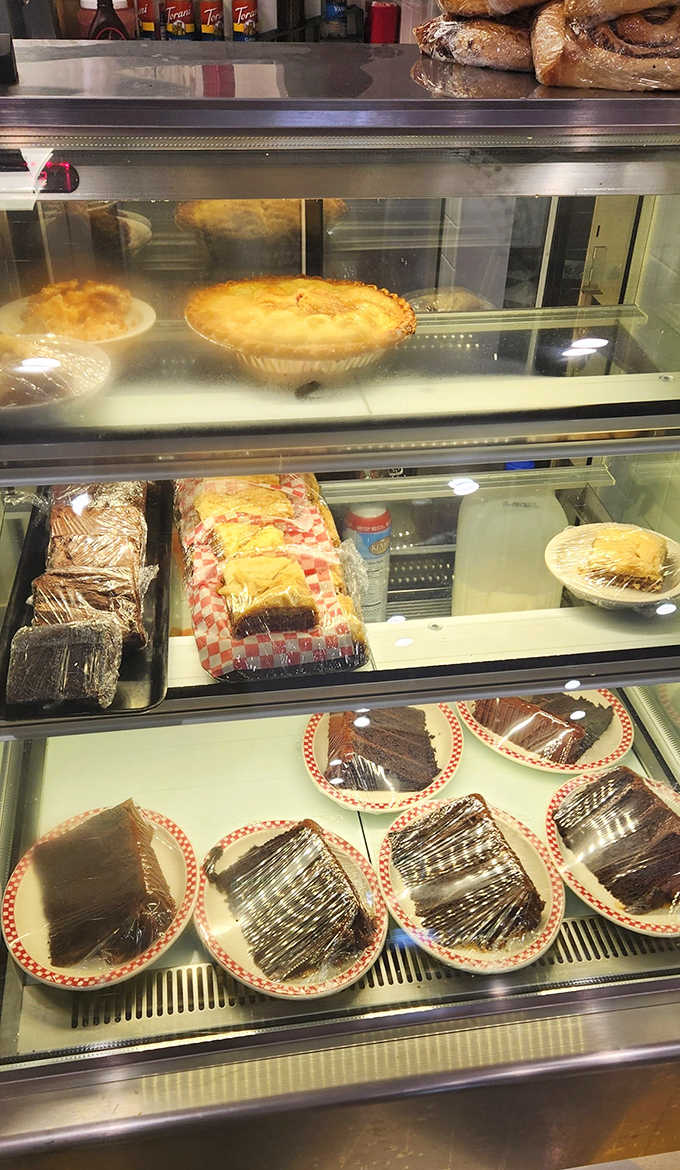 The display case – where willpower goes to die and dessert dreams come true, one slice of homemade pie at a time.