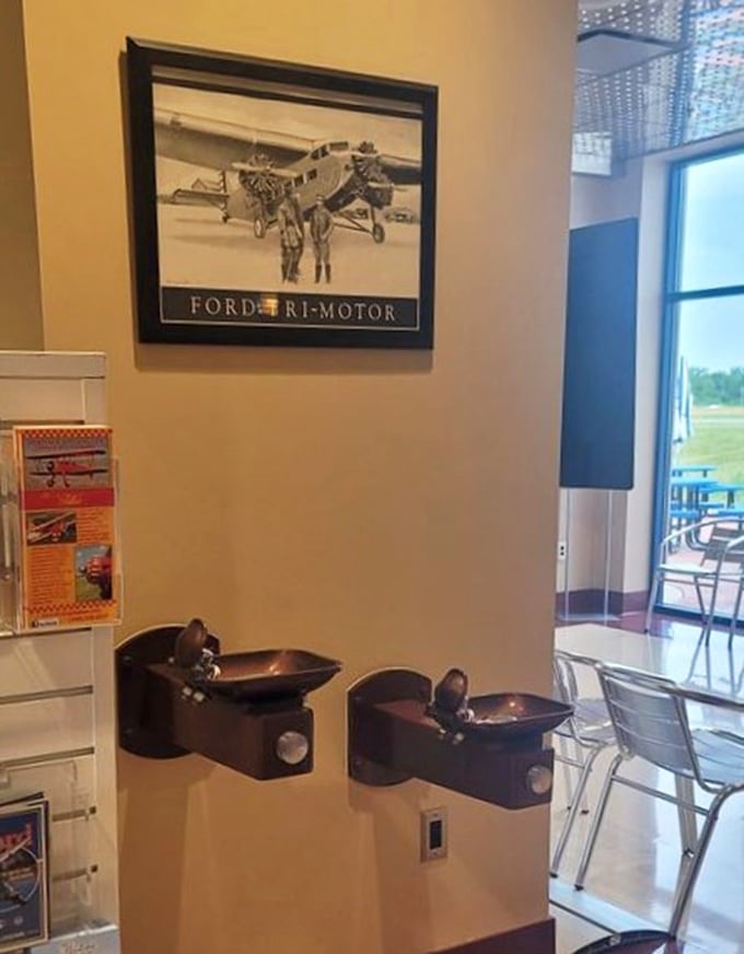 Even the water fountains maintain the vintage aesthetic – mounted beneath a classic aviation poster that celebrates America's flying history.