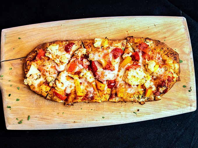This flatbread isn't just food – it's an edible canvas where cheese and toppings create a masterpiece that belongs in your mouth.